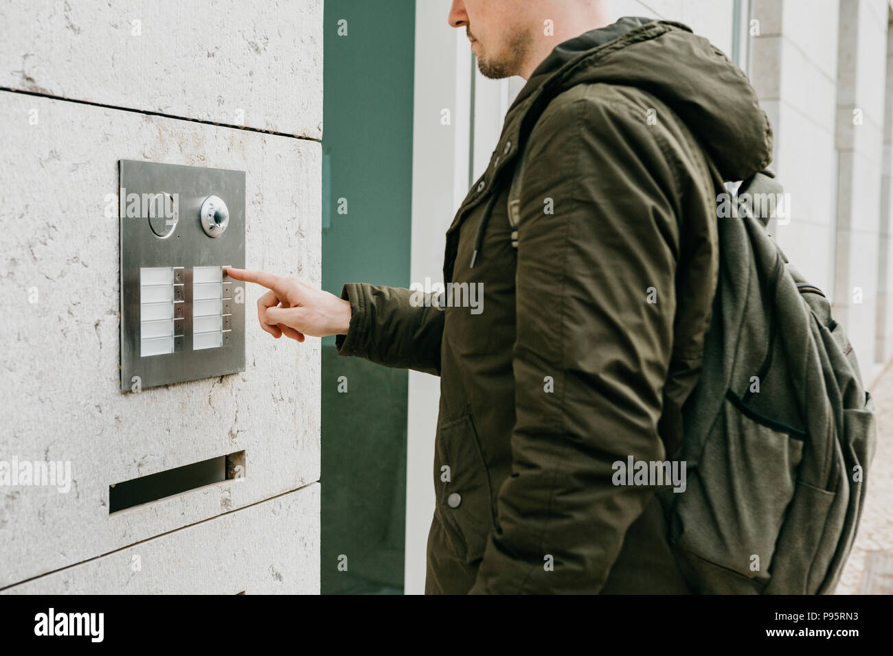 A male local resident or tourist clicks on the doorphone button or ...