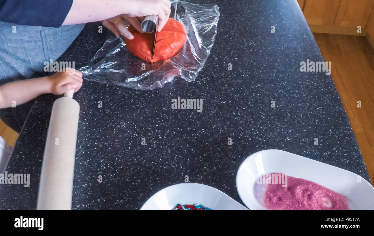 Step by step. Mother and daughter baking sugar cookies in the kitchen ...