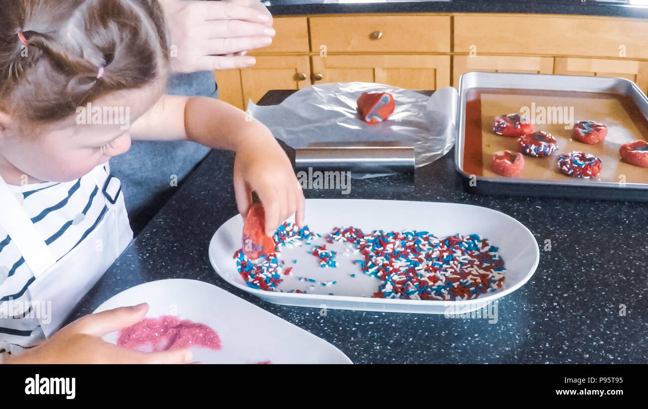 Step by step. Mother and daughter baking sugar cookies in the kitchen ...