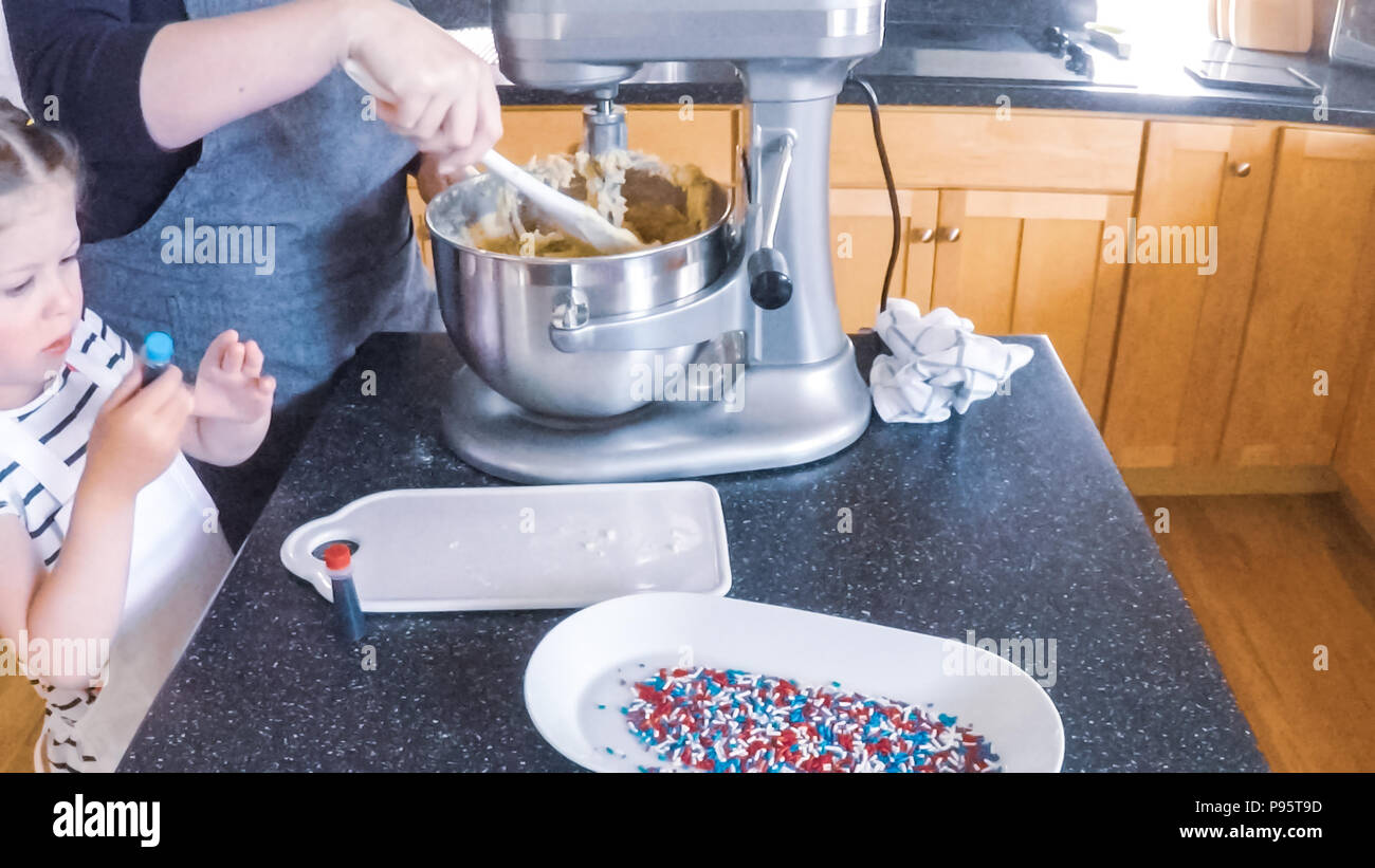 Step by step. Mother and daughter baking sugar cookies in the kitchen ...