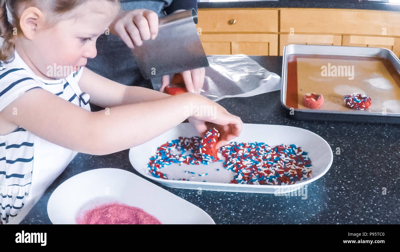 Step by step. Mother and daughter baking sugar cookies in the kitchen ...
