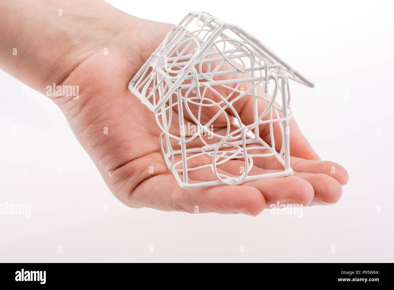 Little model house made of white metal wire in hand Stock Photo - Alamy