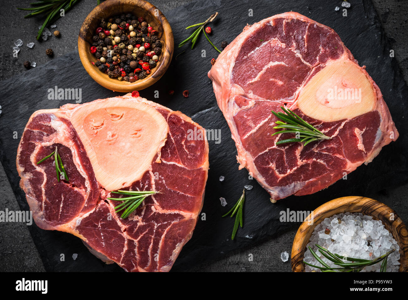 Raw beef steak osso bucco on black stone table. Marble meat. Top view ...