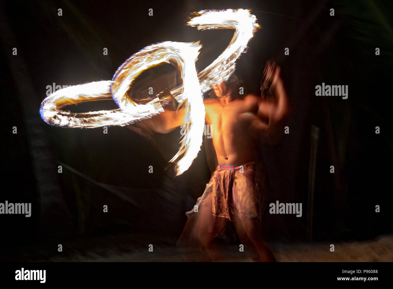 polynesian dancer using flame pole on black background Stock Photo - Alamy