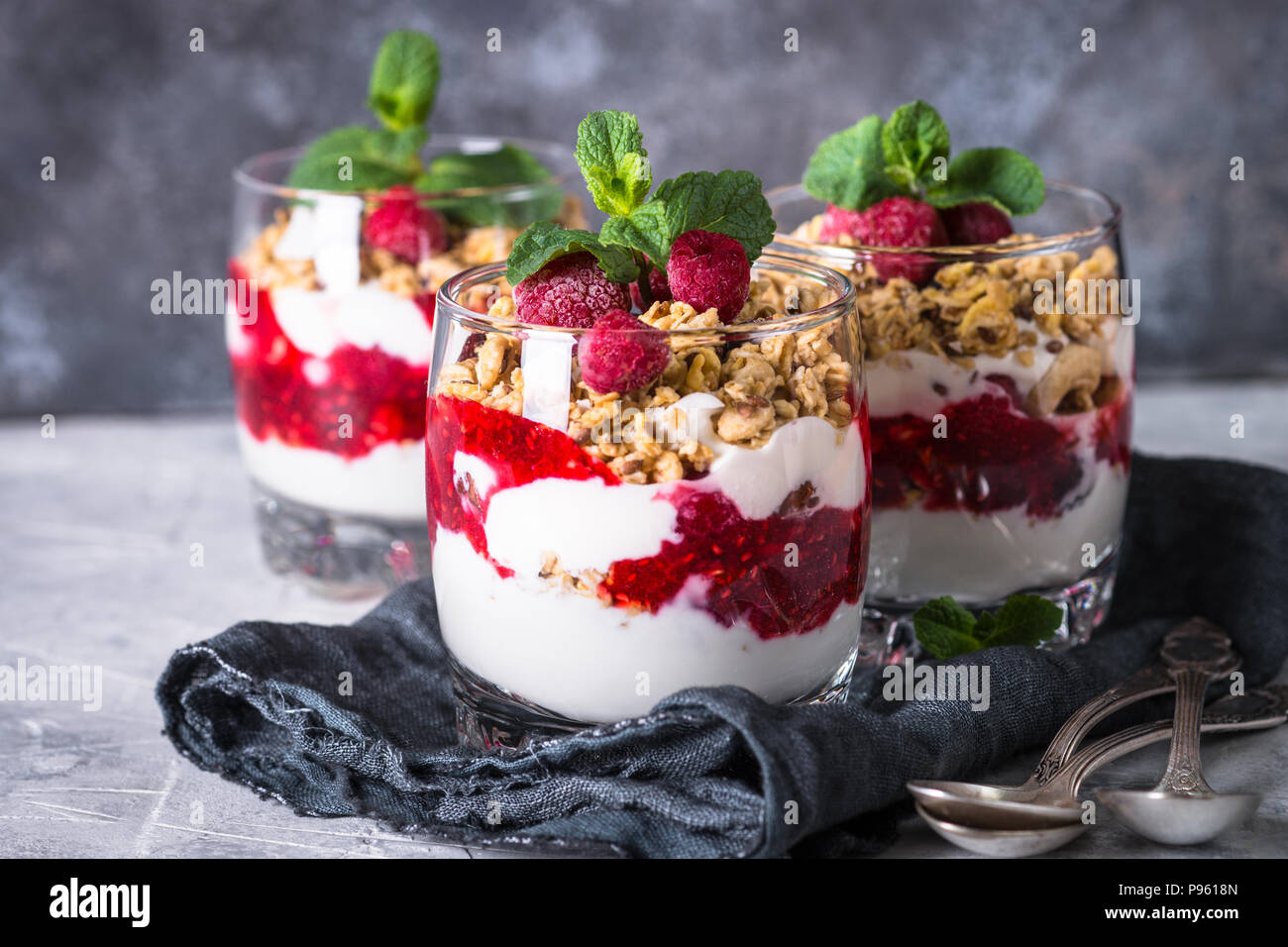 Healthy layered dessert with yogurt, granola, jam and raspberries in ...