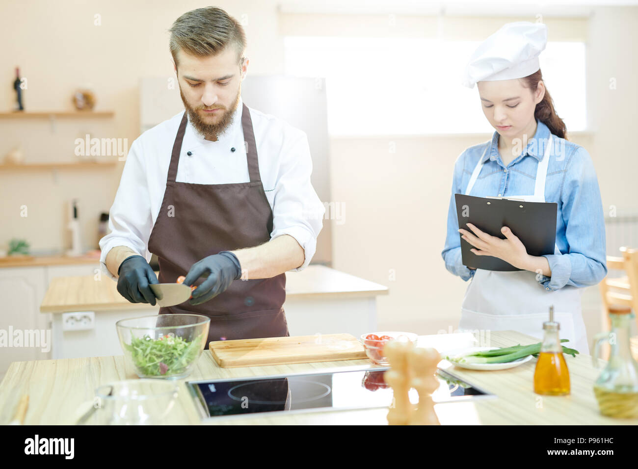 Young Chef Working in Restaurant with assistant Stock Photo - Alamy