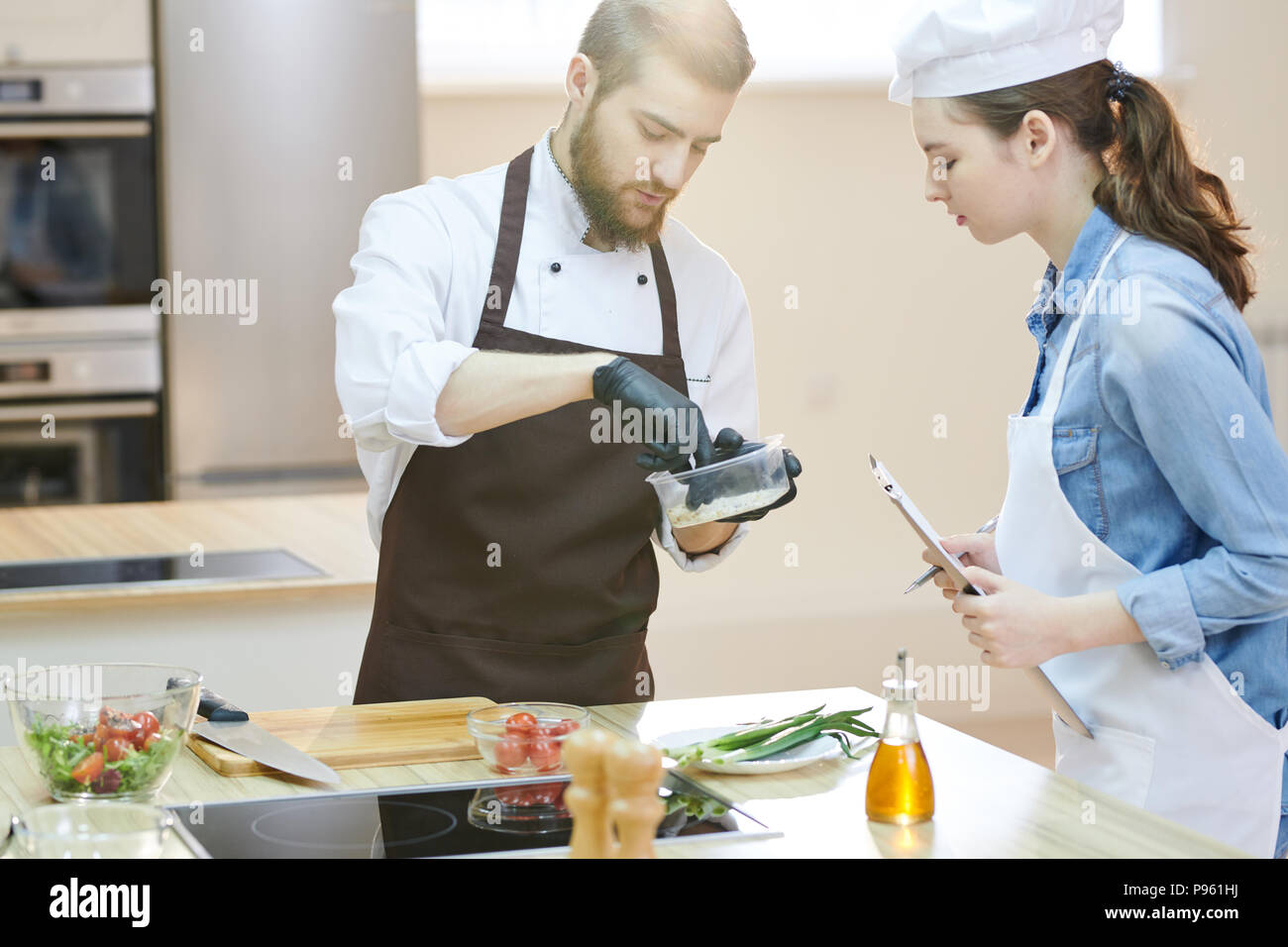 Professional Chef Working in Kitchen with Female assistant Stock Photo ...