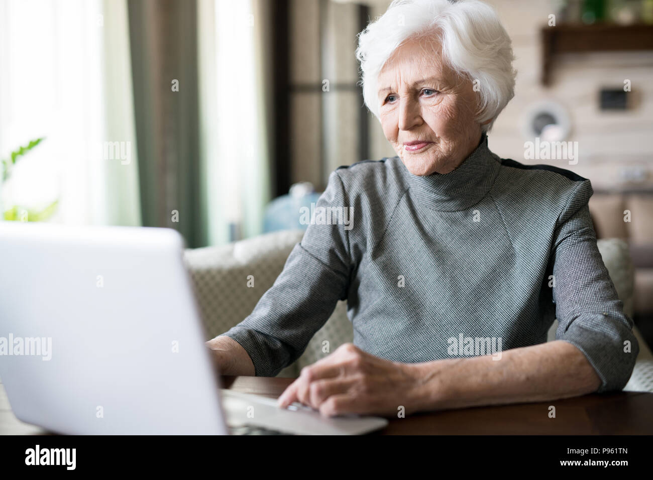 Senior woman using laptop Stock Photo - Alamy