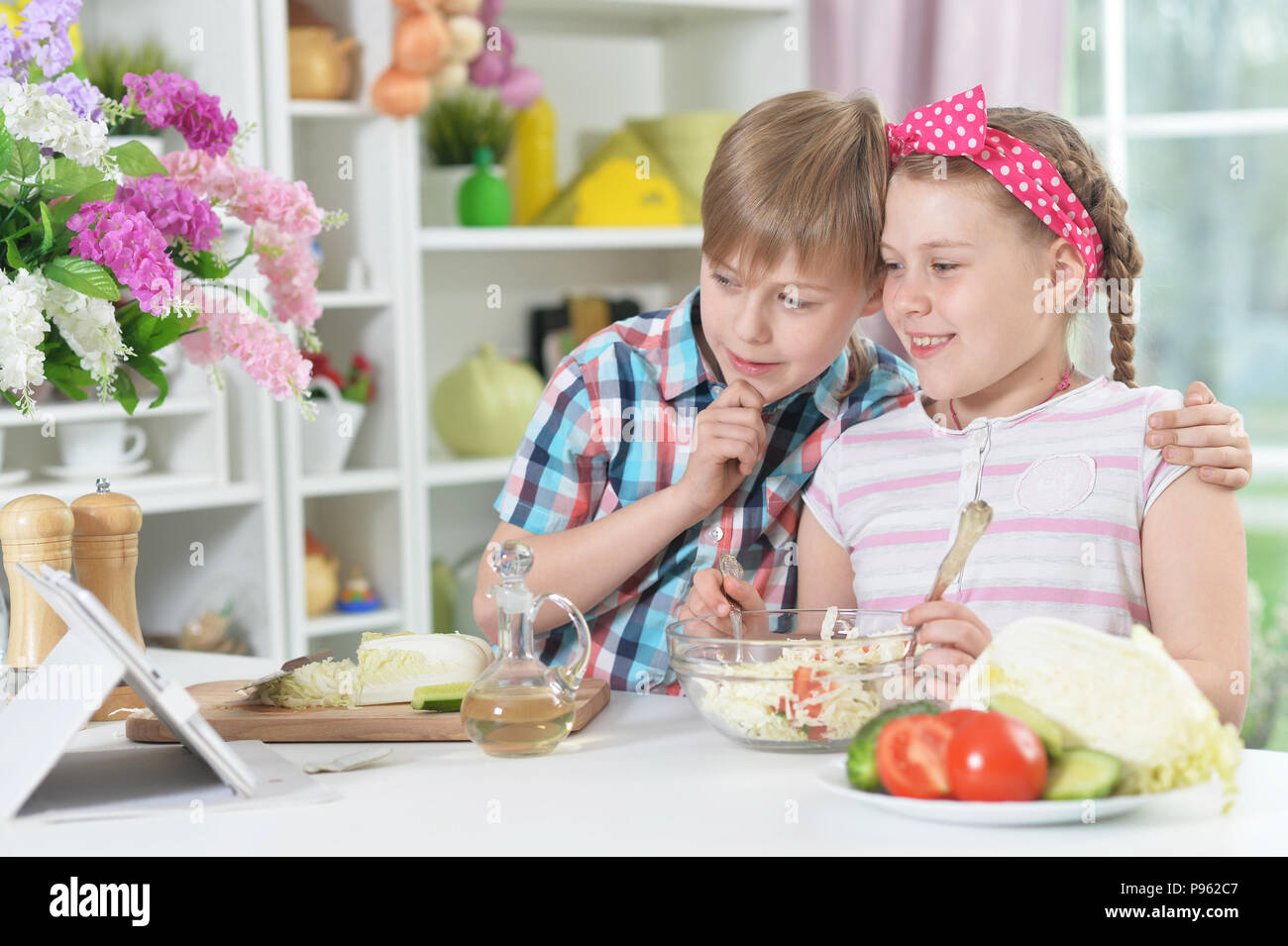 Cute brother and sister cooking together in kitchen at home Stock Photo ...