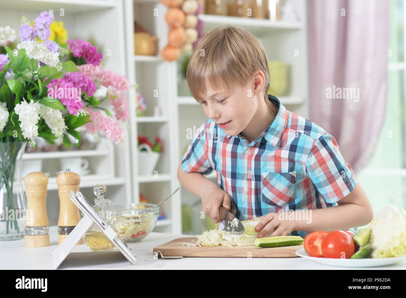 Cute little boy making dinner on kitchen table at home Stock Photo - Alamy