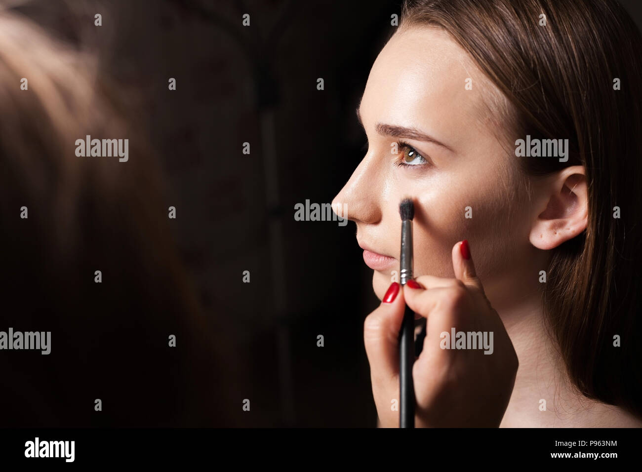 makeup artist dabbing foundation on a model Stock Photo - Alamy