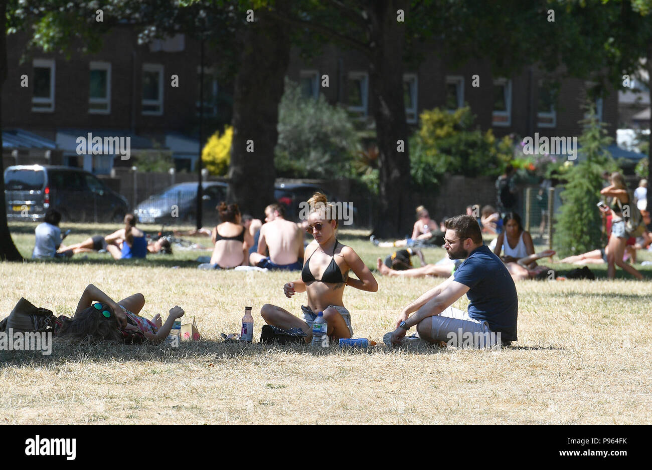 People sunbathe in Haggerston Park, in Hackney east London as the hot ...