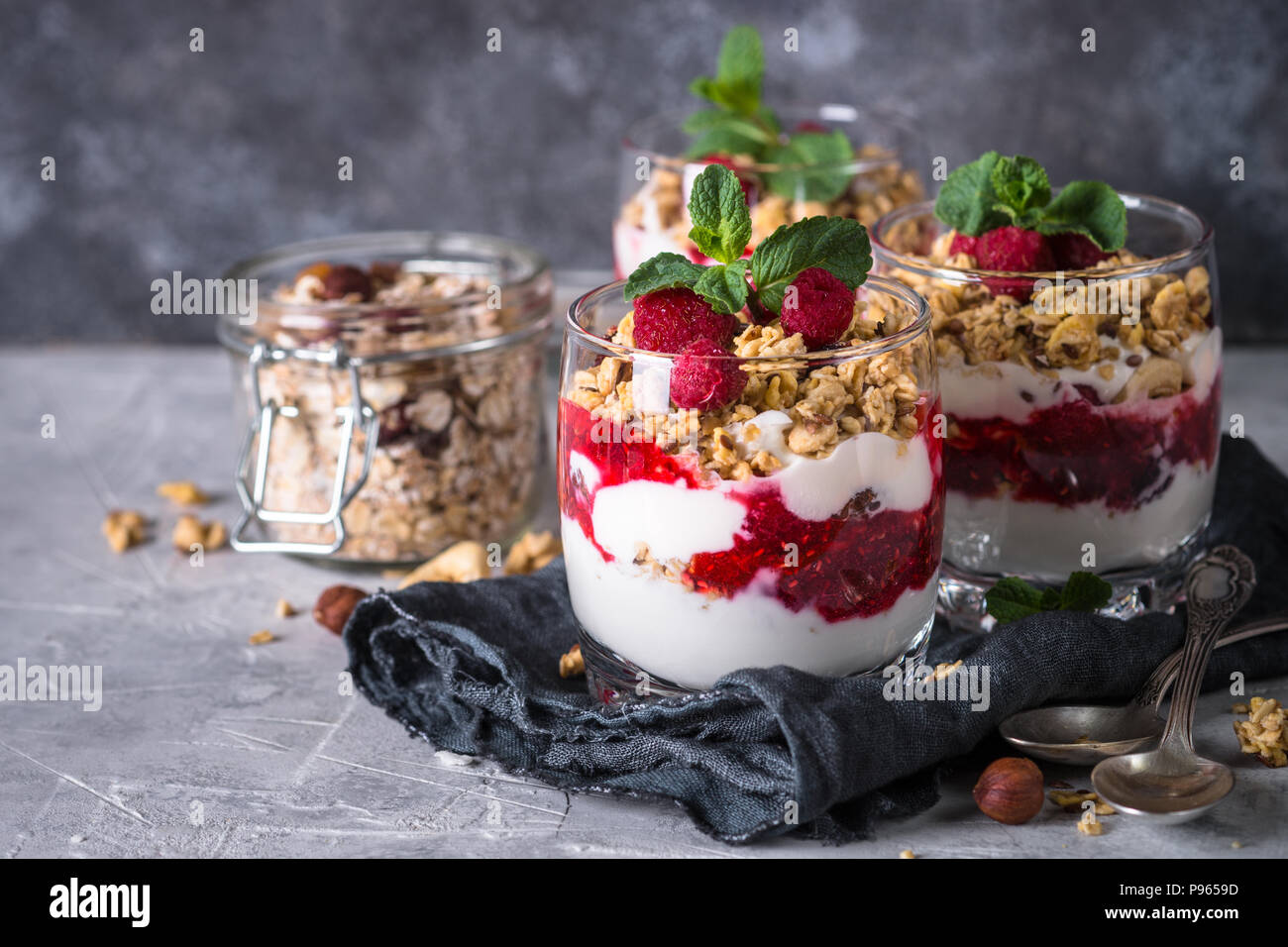 Healthy layered dessert with yogurt, granola, jam and raspberries in ...