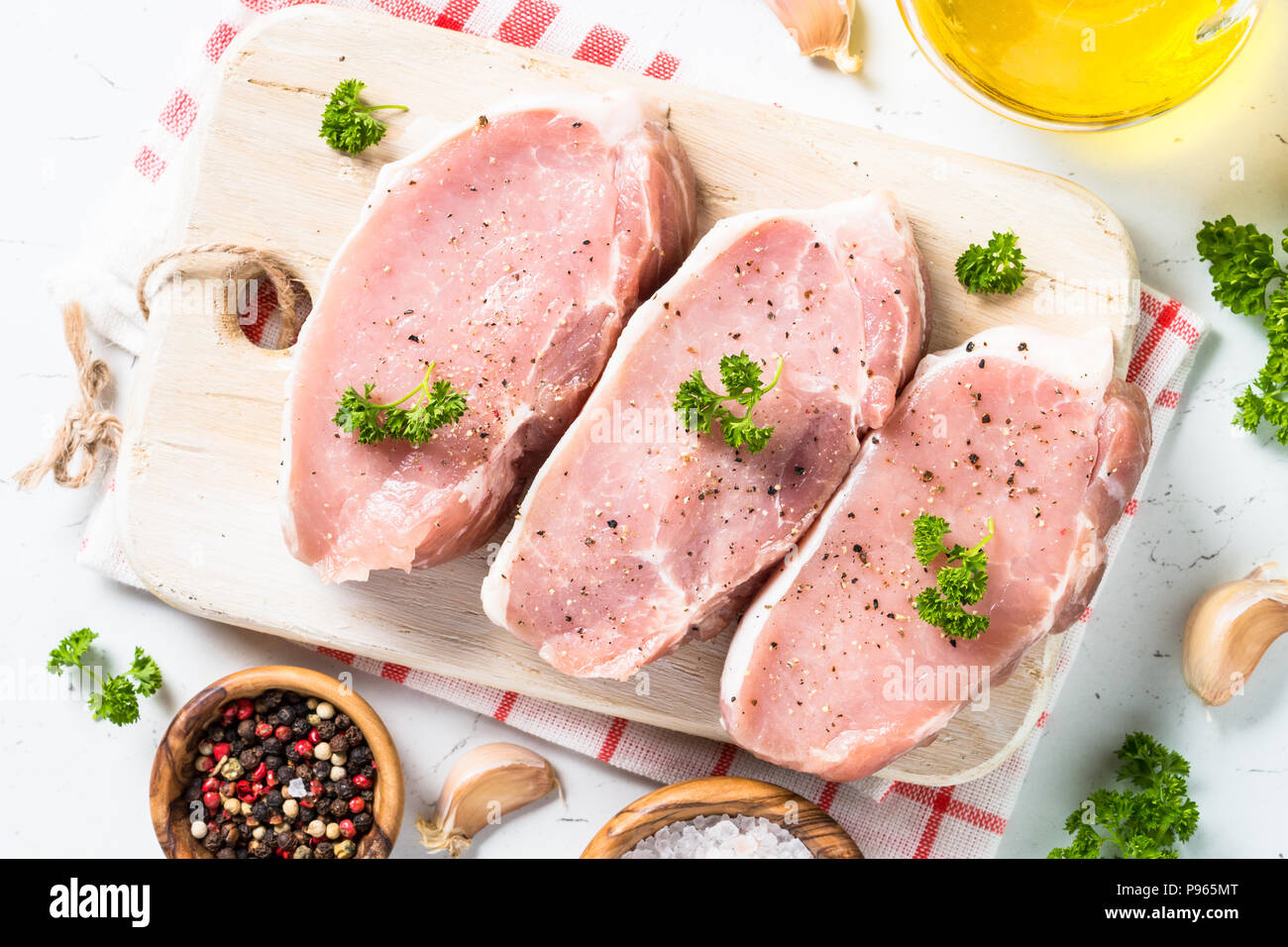 Pork meat steak, slices pork loin on white with herbs and spices. Top ...