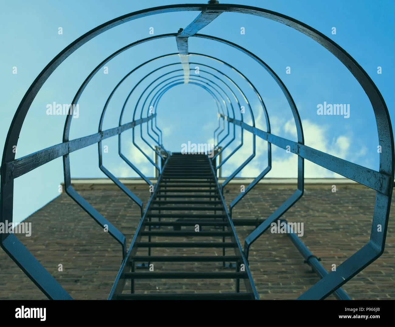 Low angle view of fire escape (safety cage) ladder on a brick wall ...