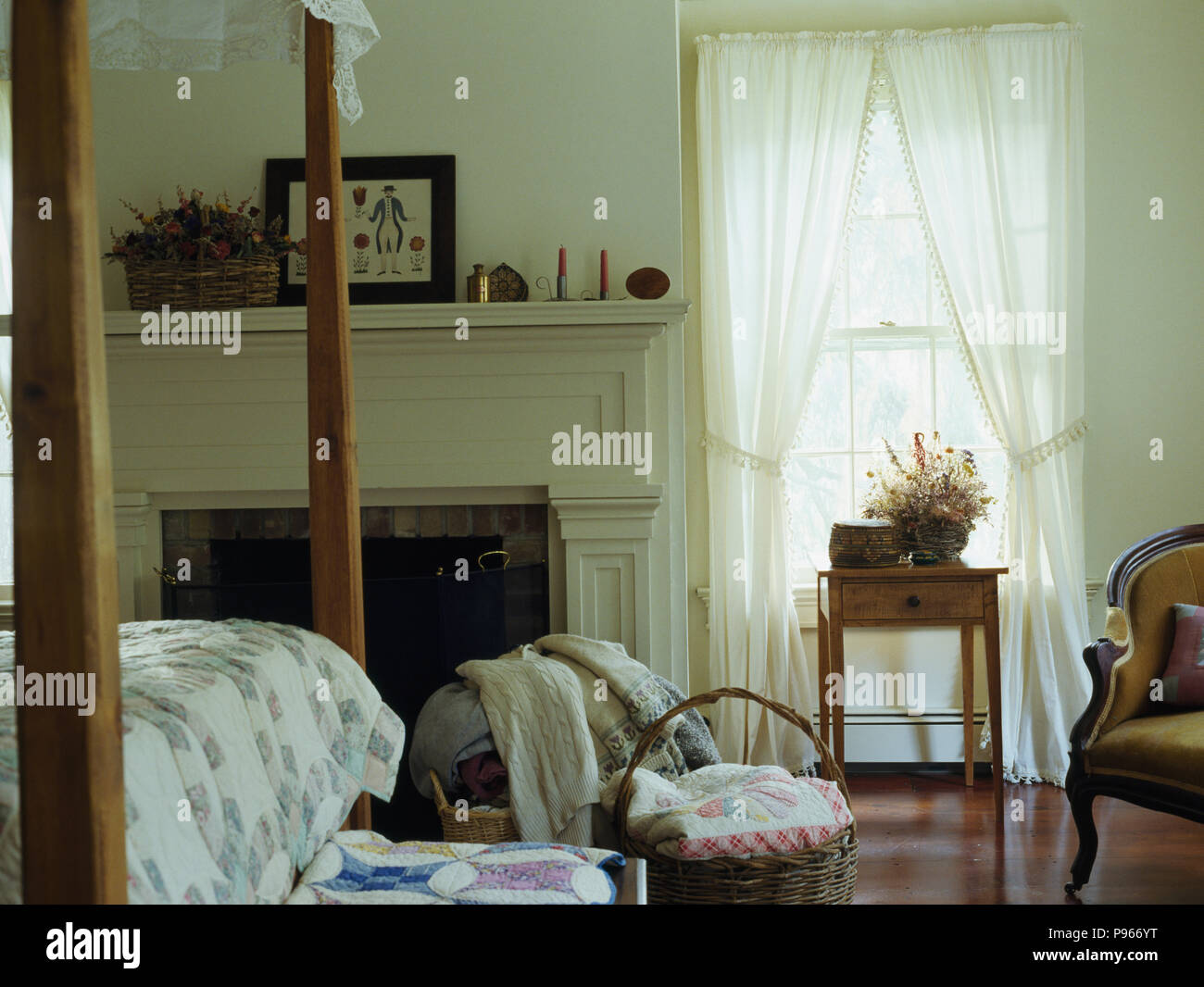 White voile curtains at window in American Colonial-style bedroom with ...