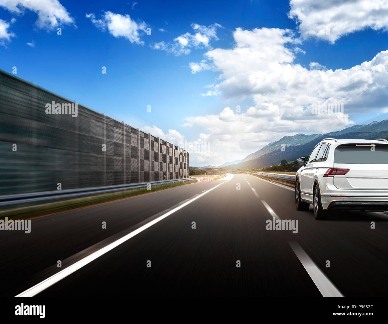 A white car rushing along a high-speed highway in the sun Stock Photo ...