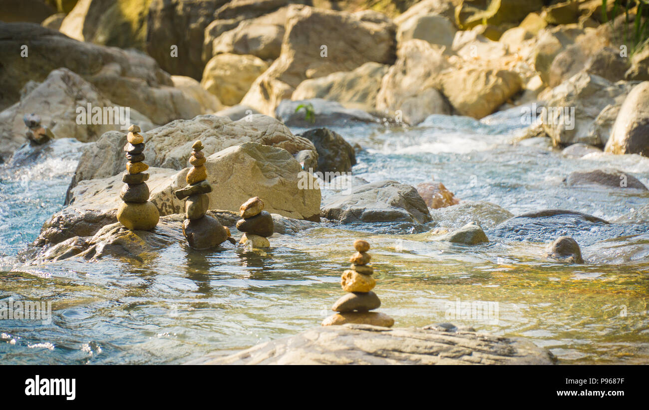 Stone stacking at a river in Curug Leuwi Hejo, Bogor Stock Photo - Alamy