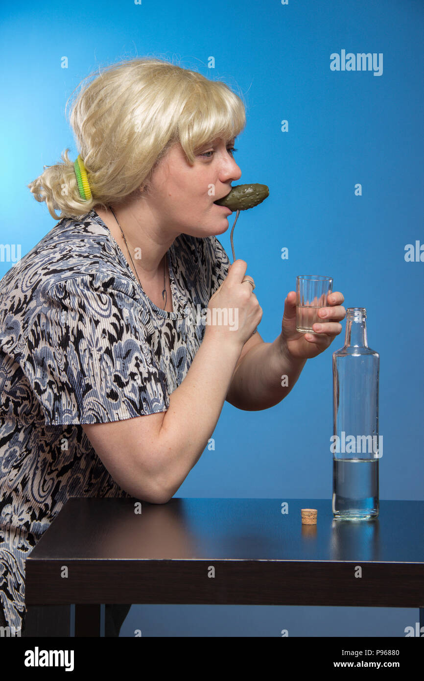 Lonely mature fat woman alcoholic drinks vodka from glasses and wine ...