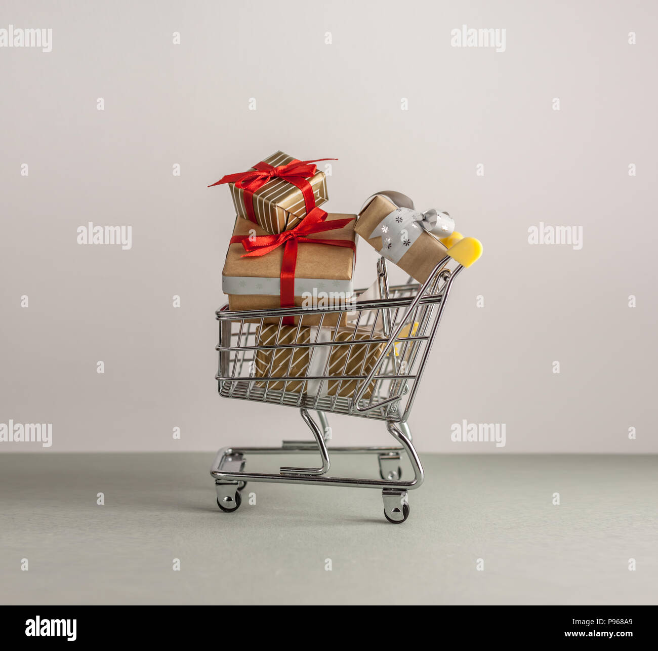 mini shopping cart with boxes with presents Stock Photo - Alamy