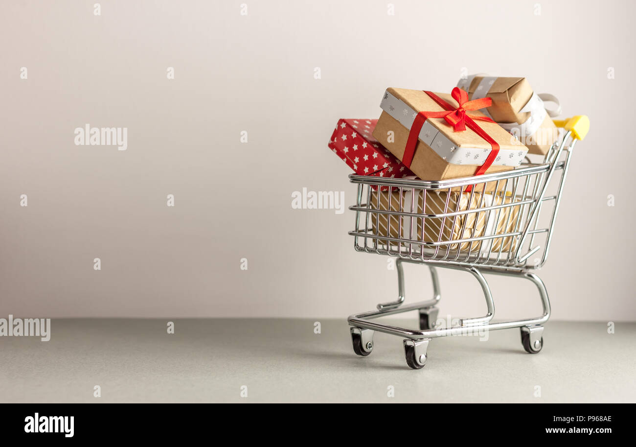 mini shopping cart with boxes with presents Stock Photo - Alamy