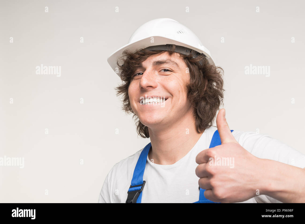Happy builder man laughing and making thumbs up on white background ...