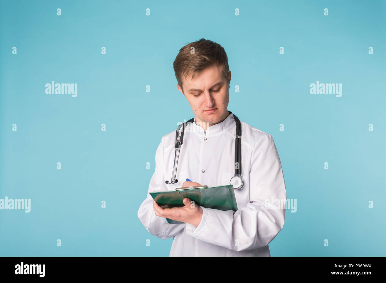 Medical doctor writing prescription over blue background Stock Photo ...