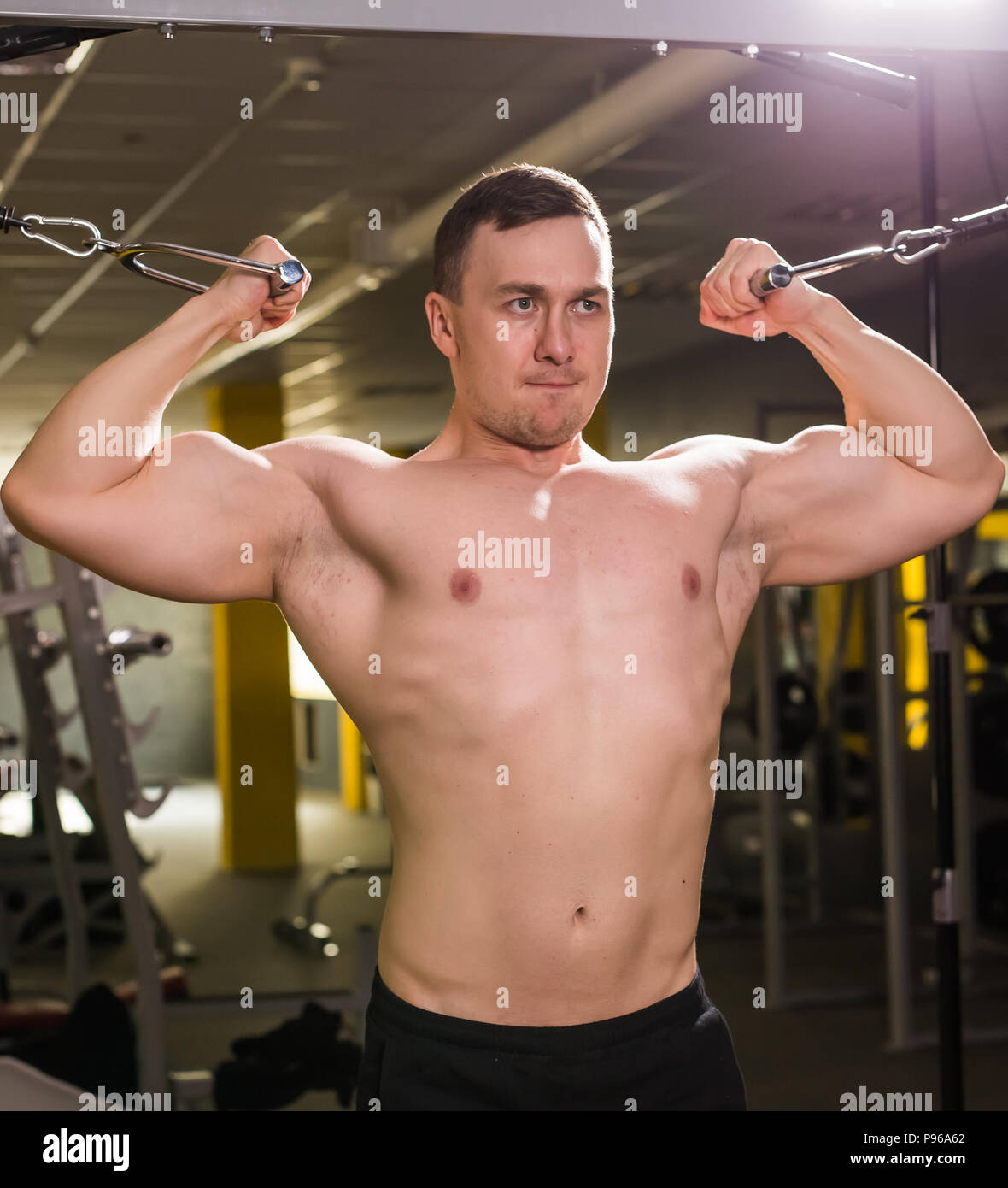 Strong muscular bodybuilder doing exercise in the gym. Fitness training ...