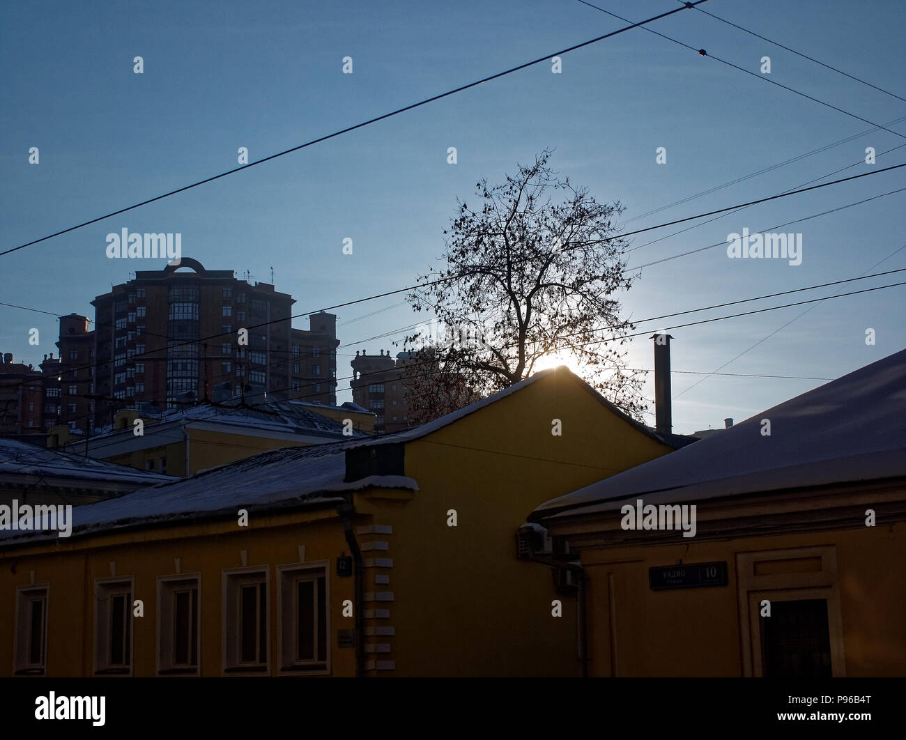 old yellow house on the background of a modern building in Moscow Stock ...