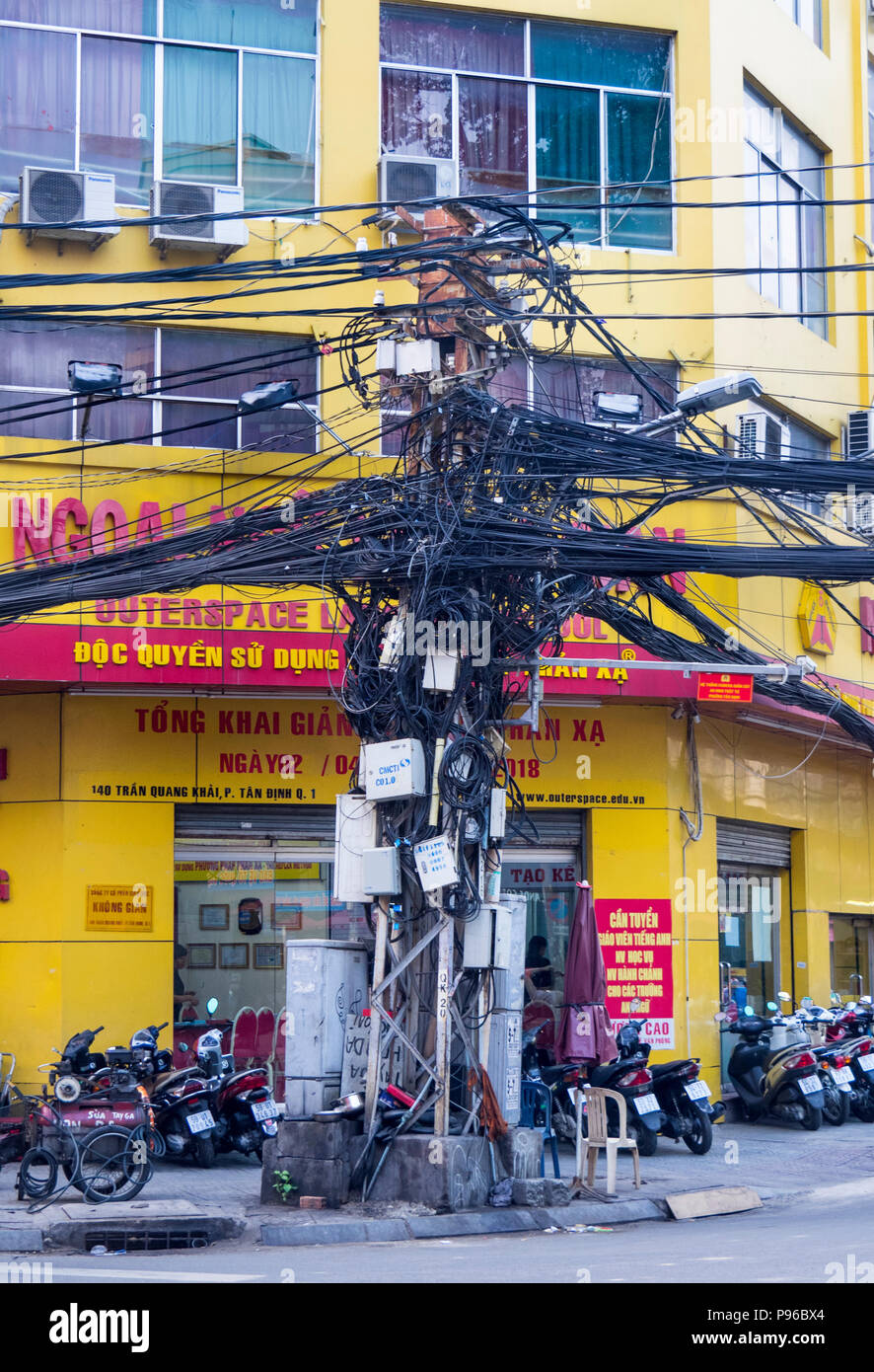 Power pole tangled with electrical power lines and telephone cables in ...