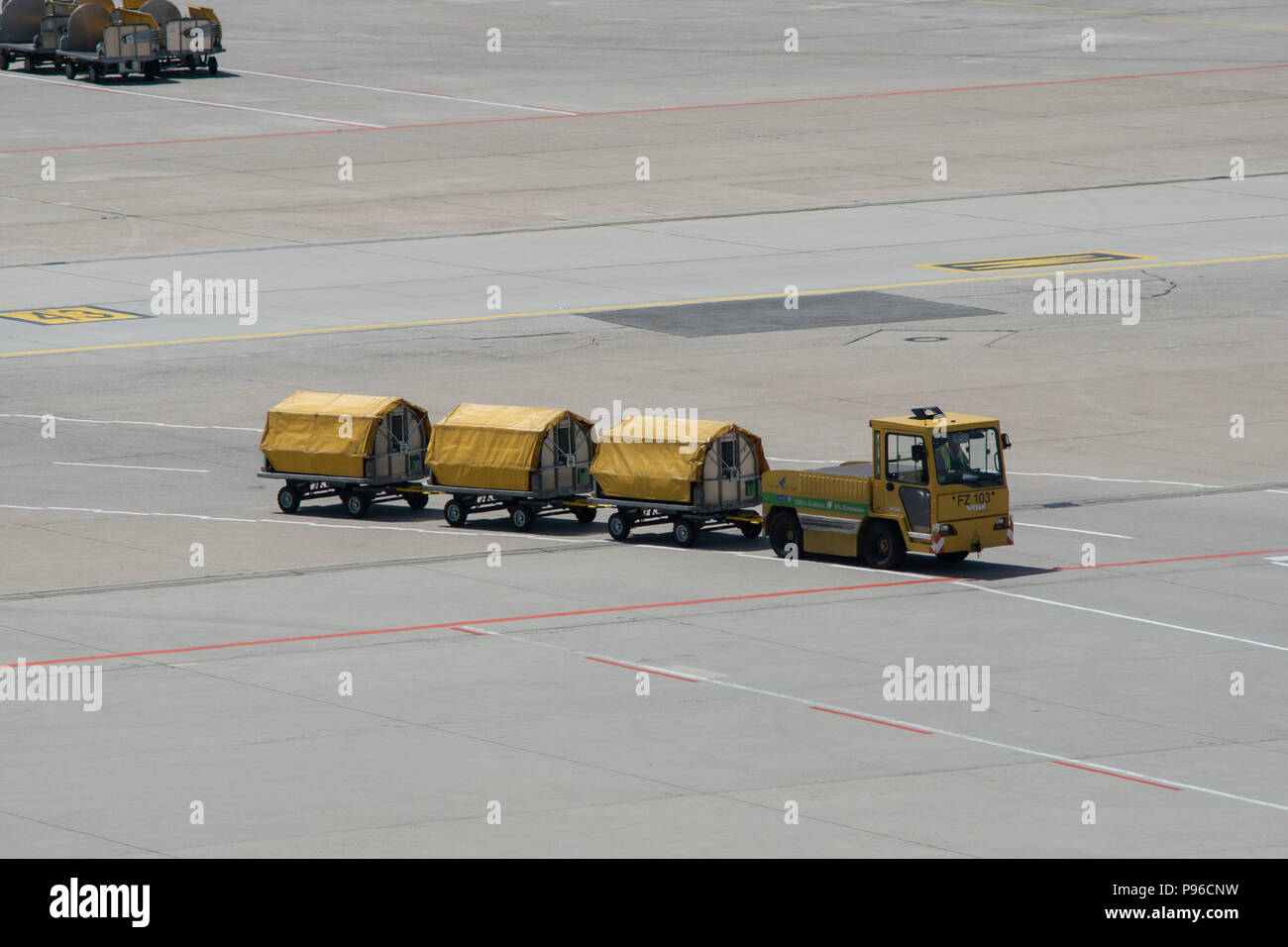 Yellow Freight trolleys with loaded baggage on the runway tarmac in ...