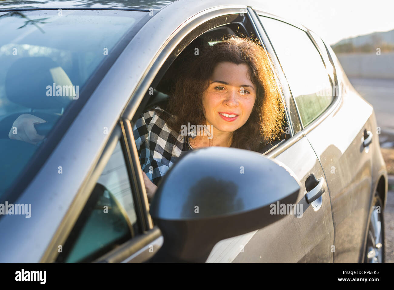 Beautiful young woman driving a car and smiling Stock Photo - Alamy