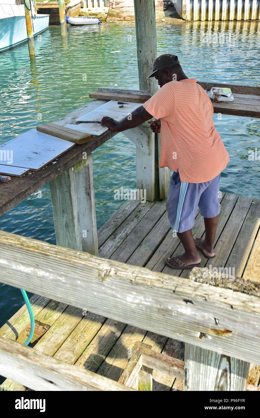 Local Bahamian man string fishing off pier in Treasure Cay Bay, Bahamas ...