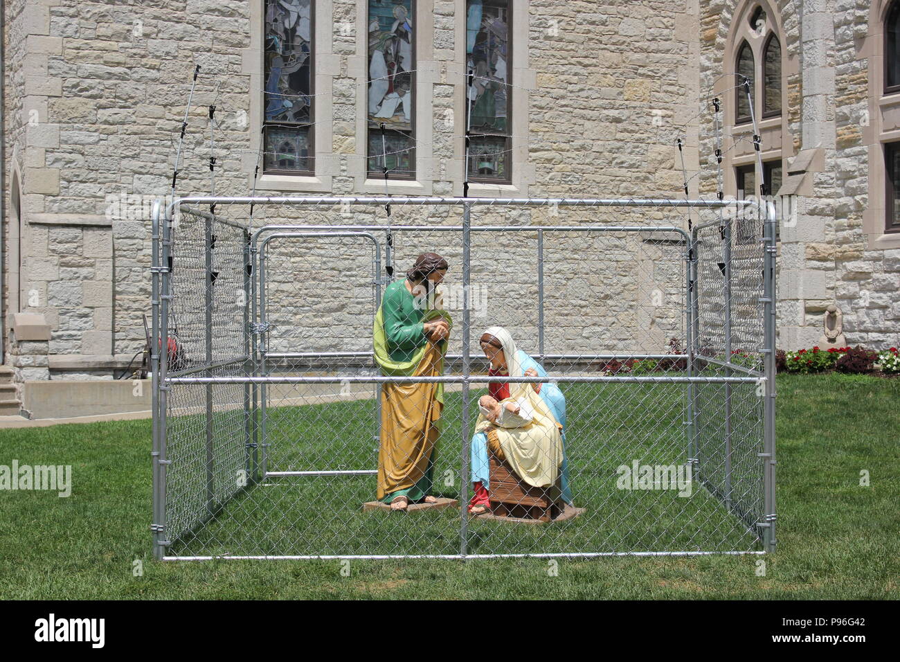 The Holy Family, Jesus, Mary, and Joseph are caged behind a barbed wire ...