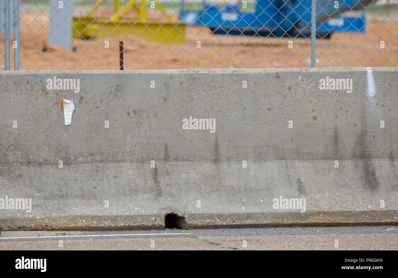 Cement bumper blocking traffic from fenced in construction area Stock ...