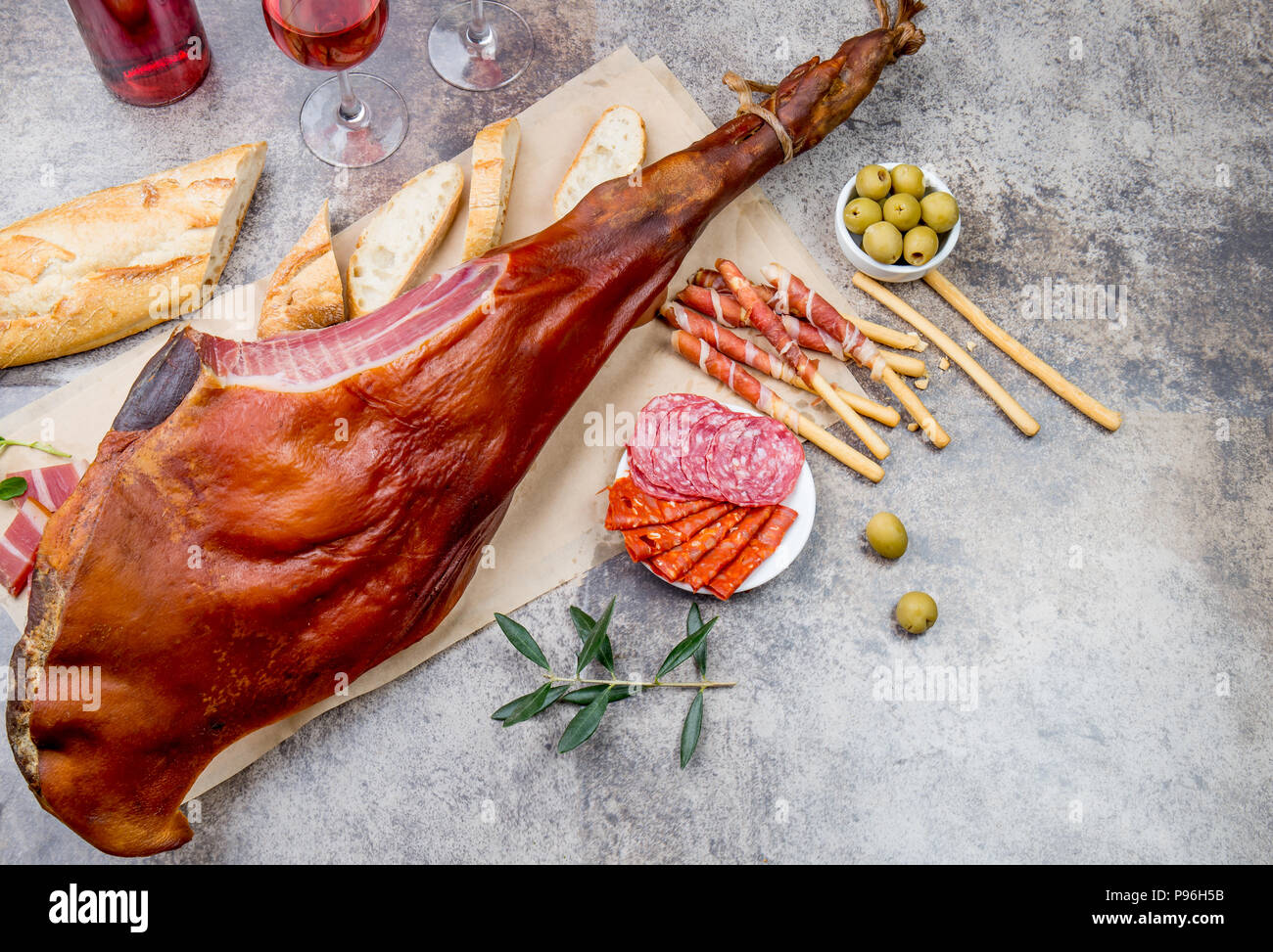 Whole leg HAM JAMON SERRANO and rose wine on gray background. Top view ...
