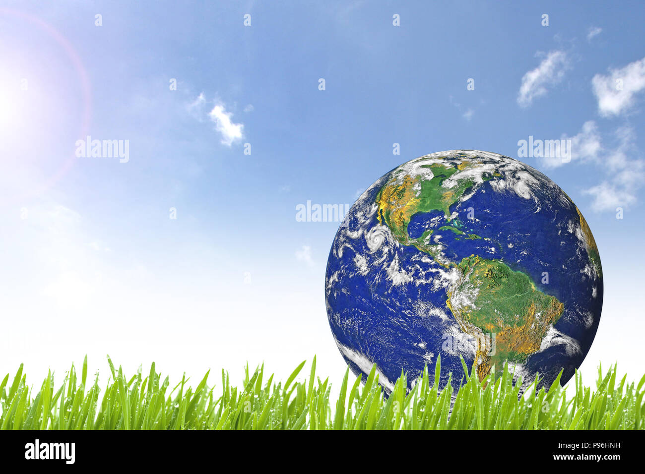 Planet Earth on beautiful green grass and sunny day with blue cloudy ...