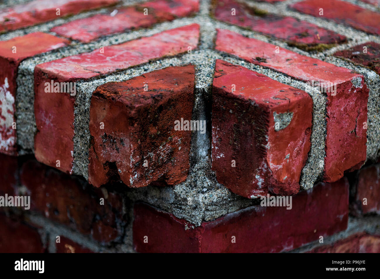 Worn aged red brick corner with a missing broken piece Stock Photo - Alamy
