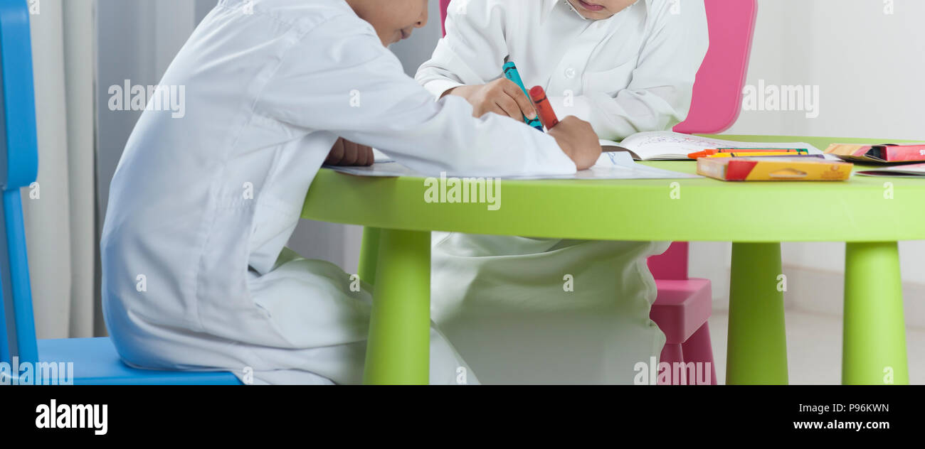 Kids drawing with colored crayons on paper at a table Stock Photo - Alamy