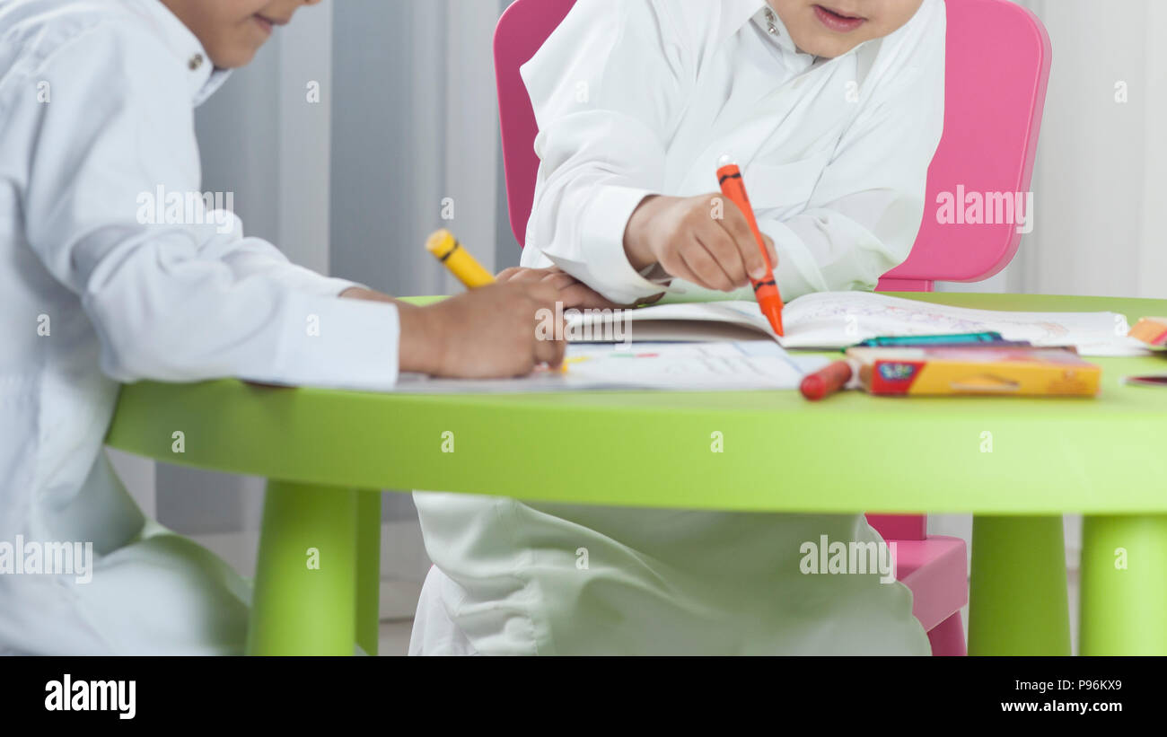 Kids drawing with colored crayons on paper at a table Stock Photo - Alamy