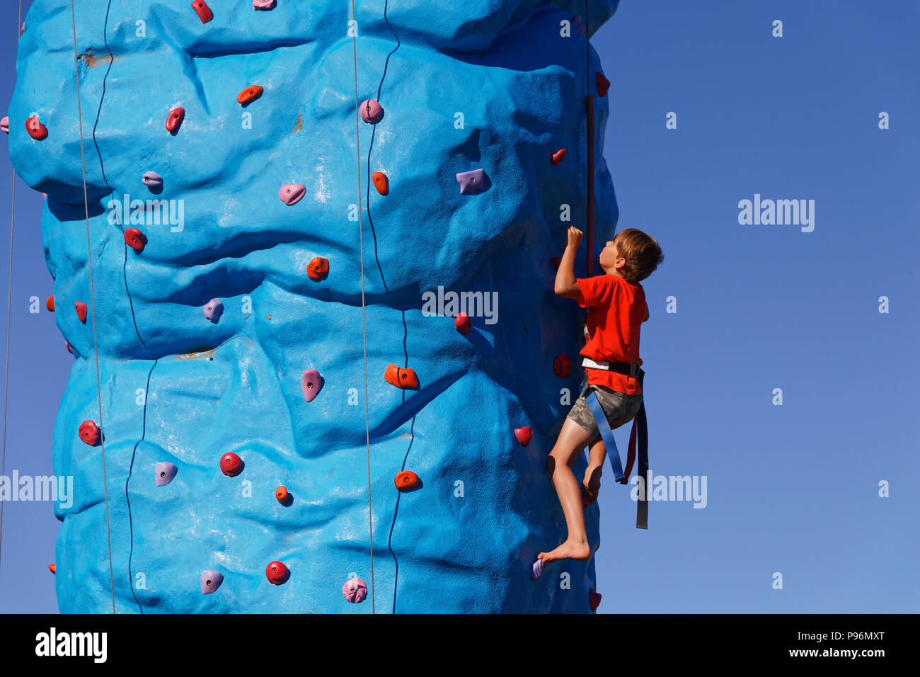 Boy climbing up a climbing wall Stock Photo - Alamy