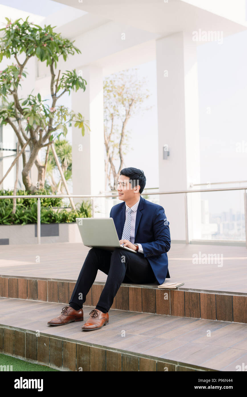 Happy young businessman using laptop hi-res stock photography and ...