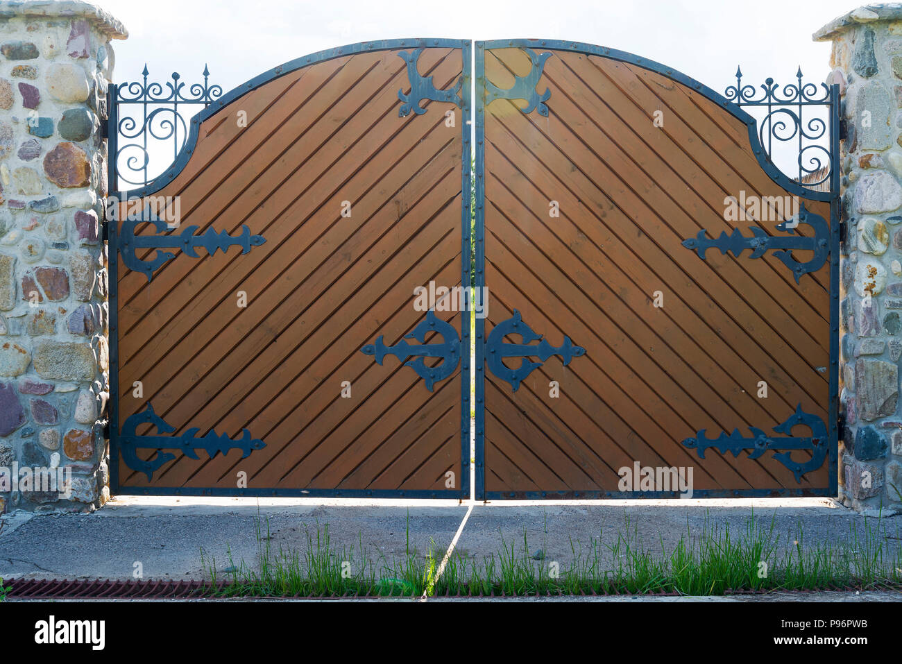 Wooden gate with wrought iron elements. Entry for cars Stock Photo - Alamy