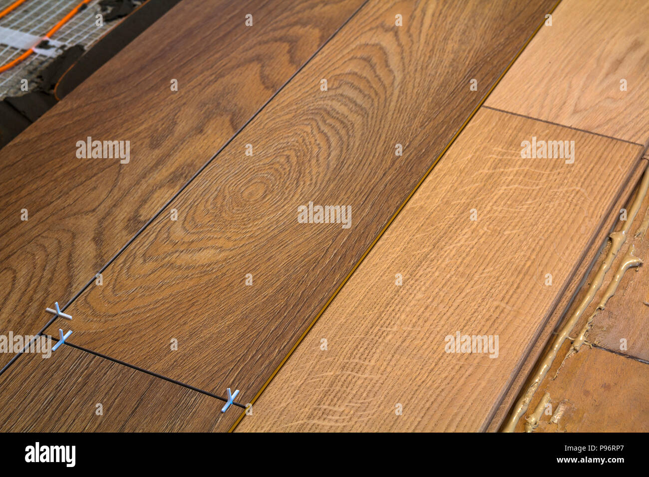 Renovation works. Close-up of installation of parquet and ceramic tile ...