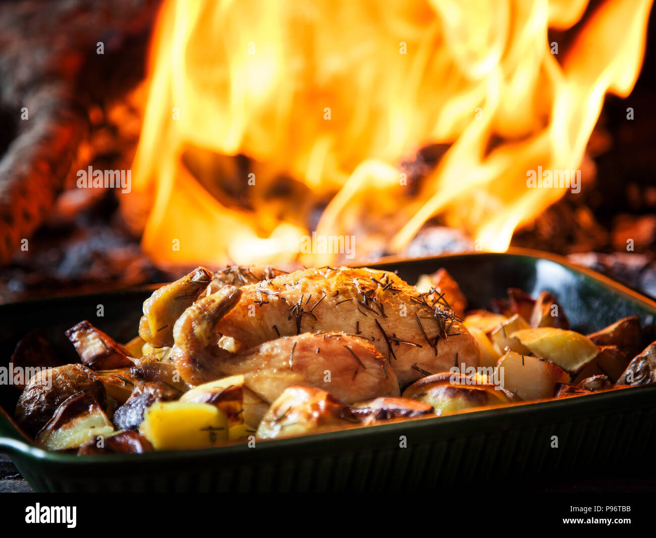 Roast chicken with potatoes rapprochement with large flame of fire ...