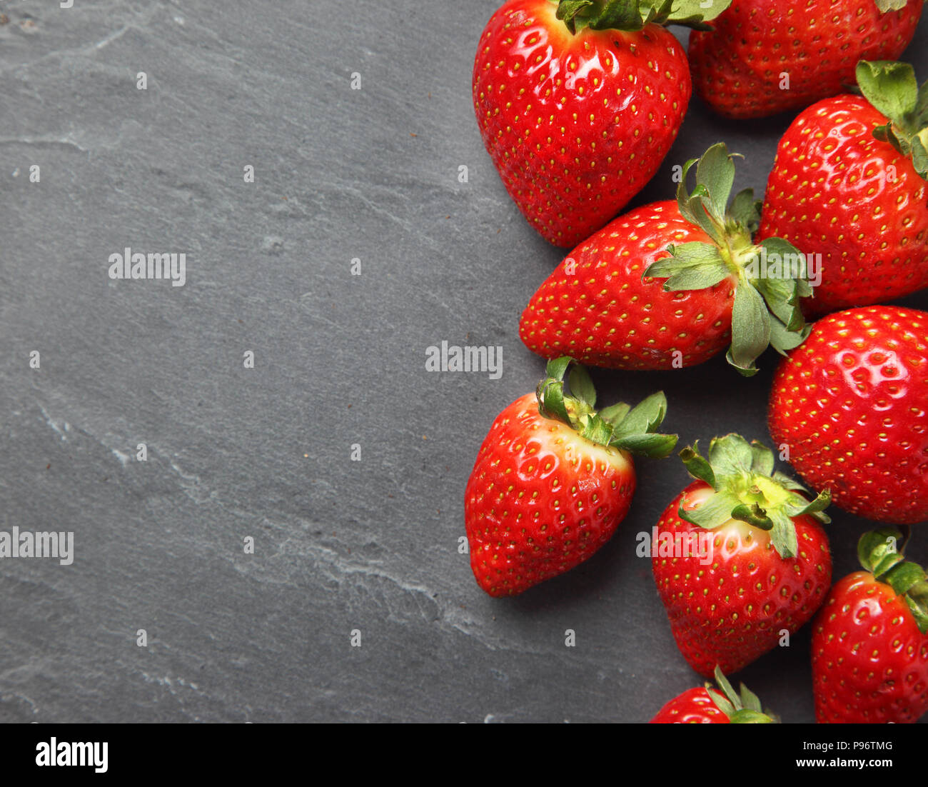 Strawberry background on stone slate Stock Photo - Alamy
