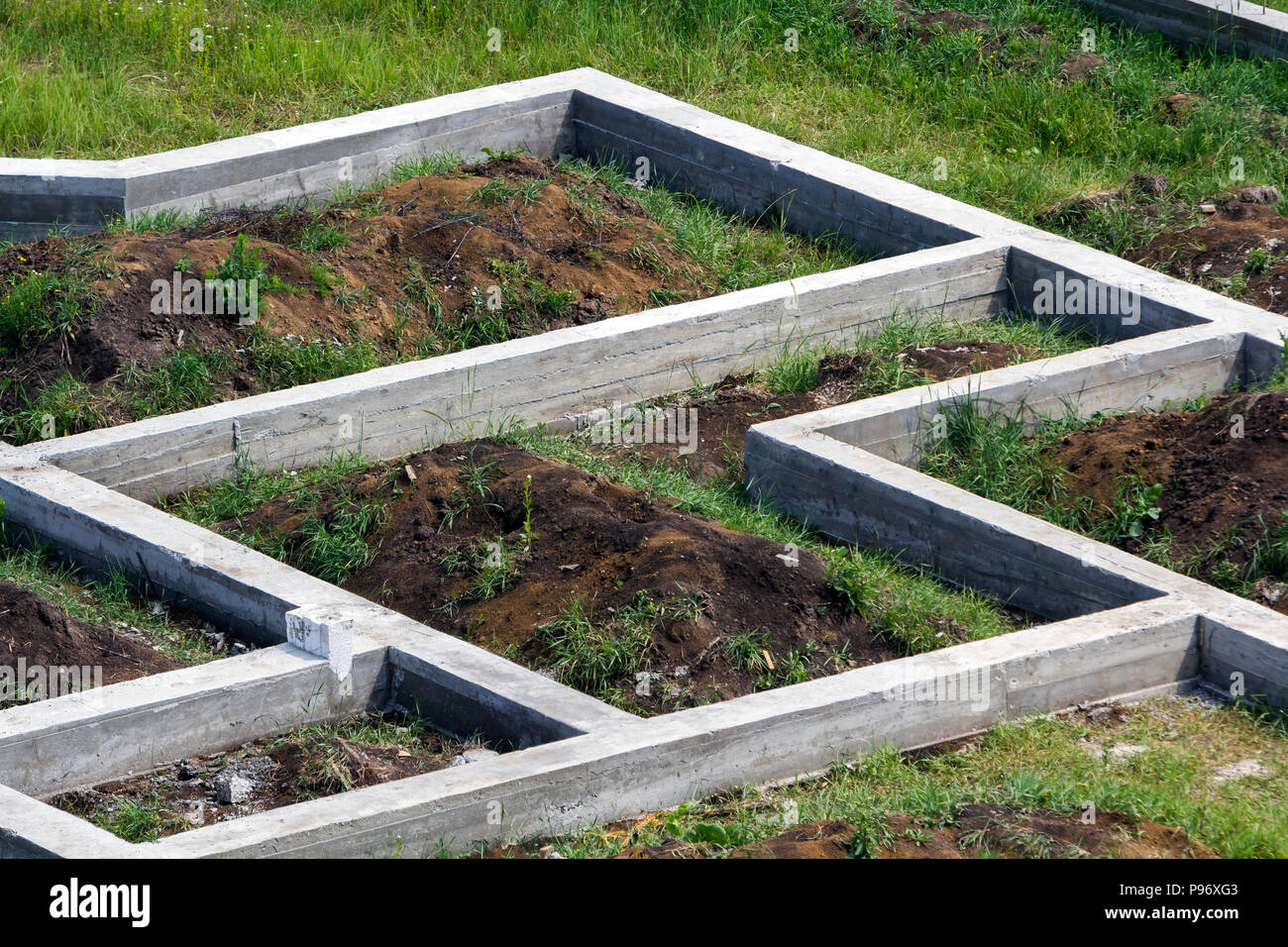 Building site in green field. Close-up detail of trenches dug in ground ...