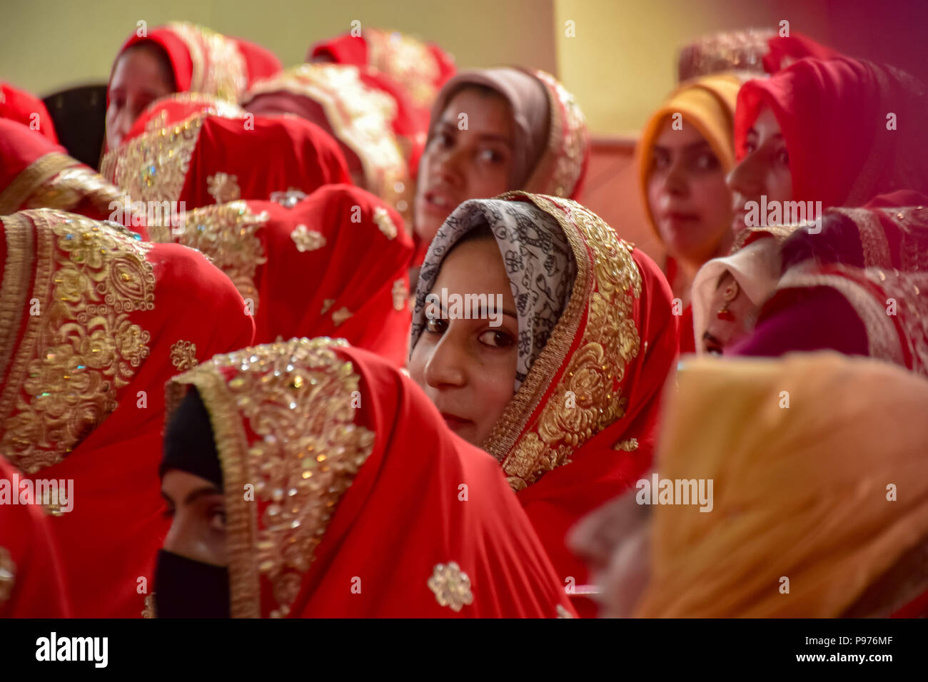 Srinagar, India. 15th July 2018. Kashmiri Muslim brides sit for a mass ...