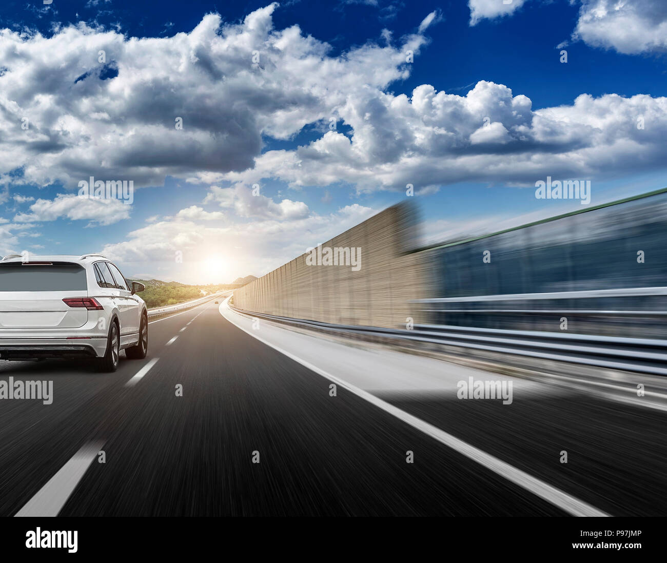 A white car rushing along a high-speed highway in the sun Stock Photo ...