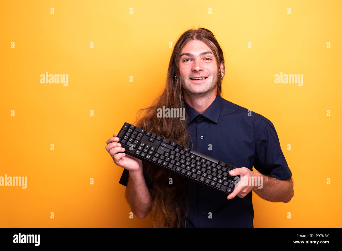 Inspiring male adult holding a keyboard Stock Photo - Alamy